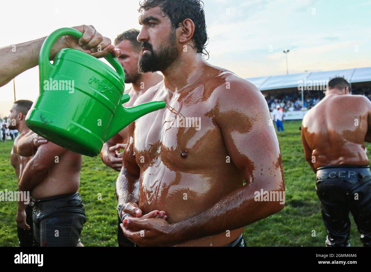 An oil wrestler gets oil on his body before the start of the ...