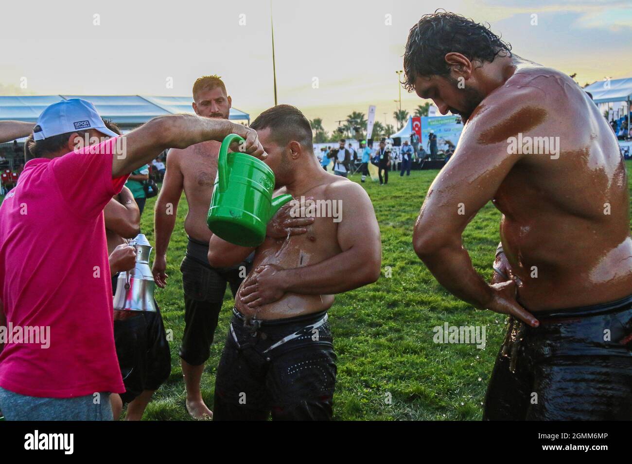 Oil wrestlers get oil on their bodies before the start of the ...