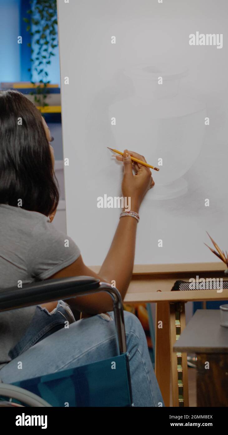 Black invalid artist with handicap using pencil on canvas for authentic ...