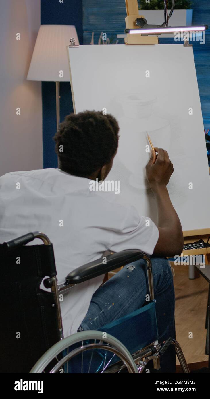 Disabled african american man working on drawing of vase with pencil ...