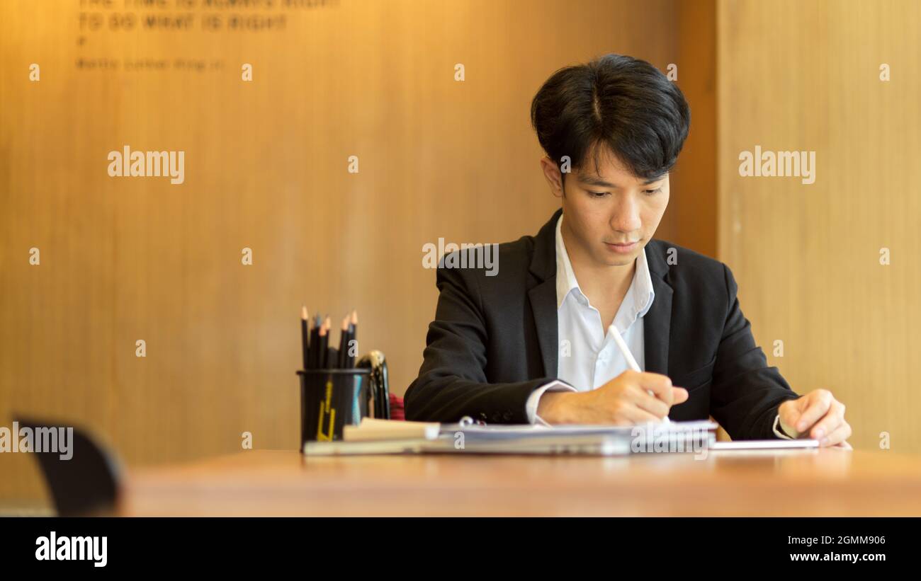 Businessman signing a document, writing down on paper, working on ...