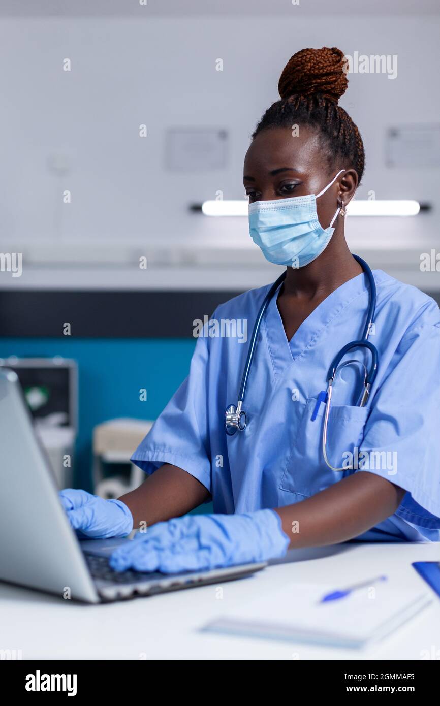 Black woman with nurse profession using modern laptop and technology ...