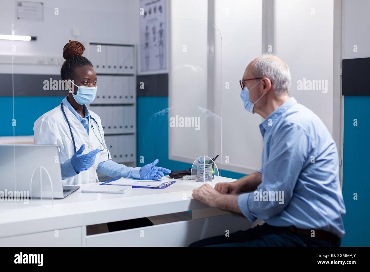 Doctor of african american ethnicity wearing face mask while talking to ...