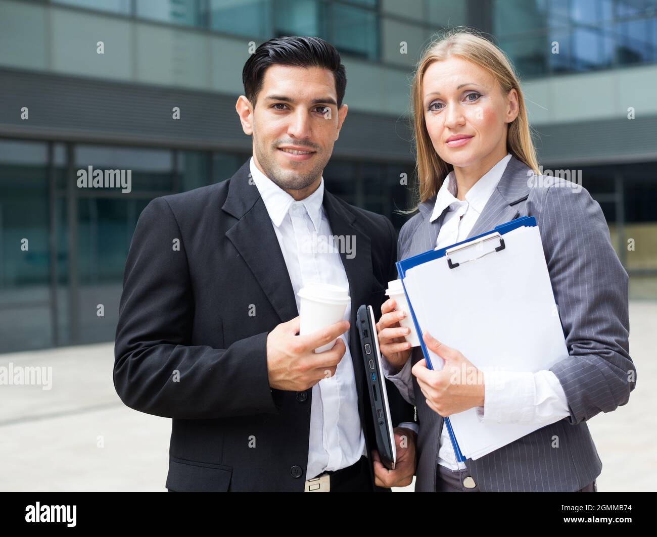 Businesswoman and her partner are standing with folder and coffee Stock ...