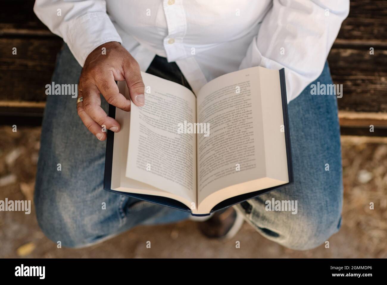Top view of an adult man enjoying reading a book while sitting on a ...