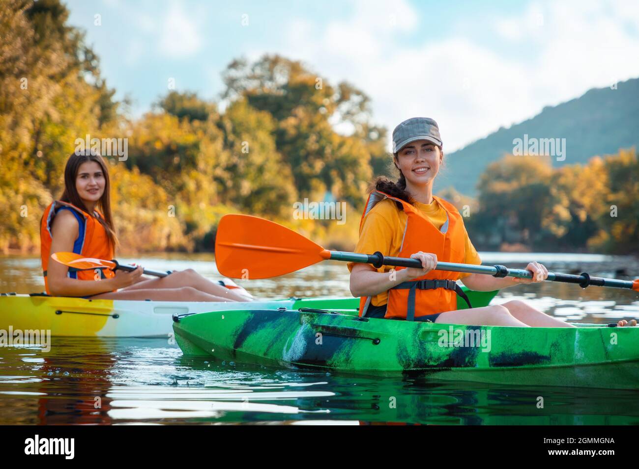 Two young happy women are kayaking. Outdoor activity. Concept of World ...
