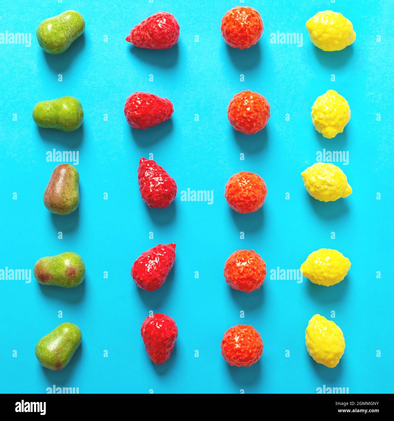 Chewing gum in the form of pear, orange, strawberry and lemon on a blue ...