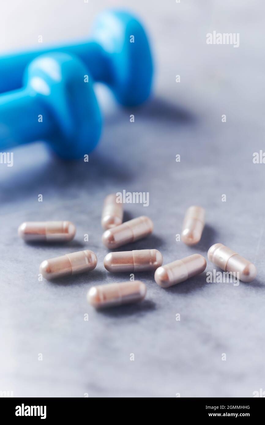 Sport Supplements ( Carnitine Capsules ) and Blue Dumbbells in ...