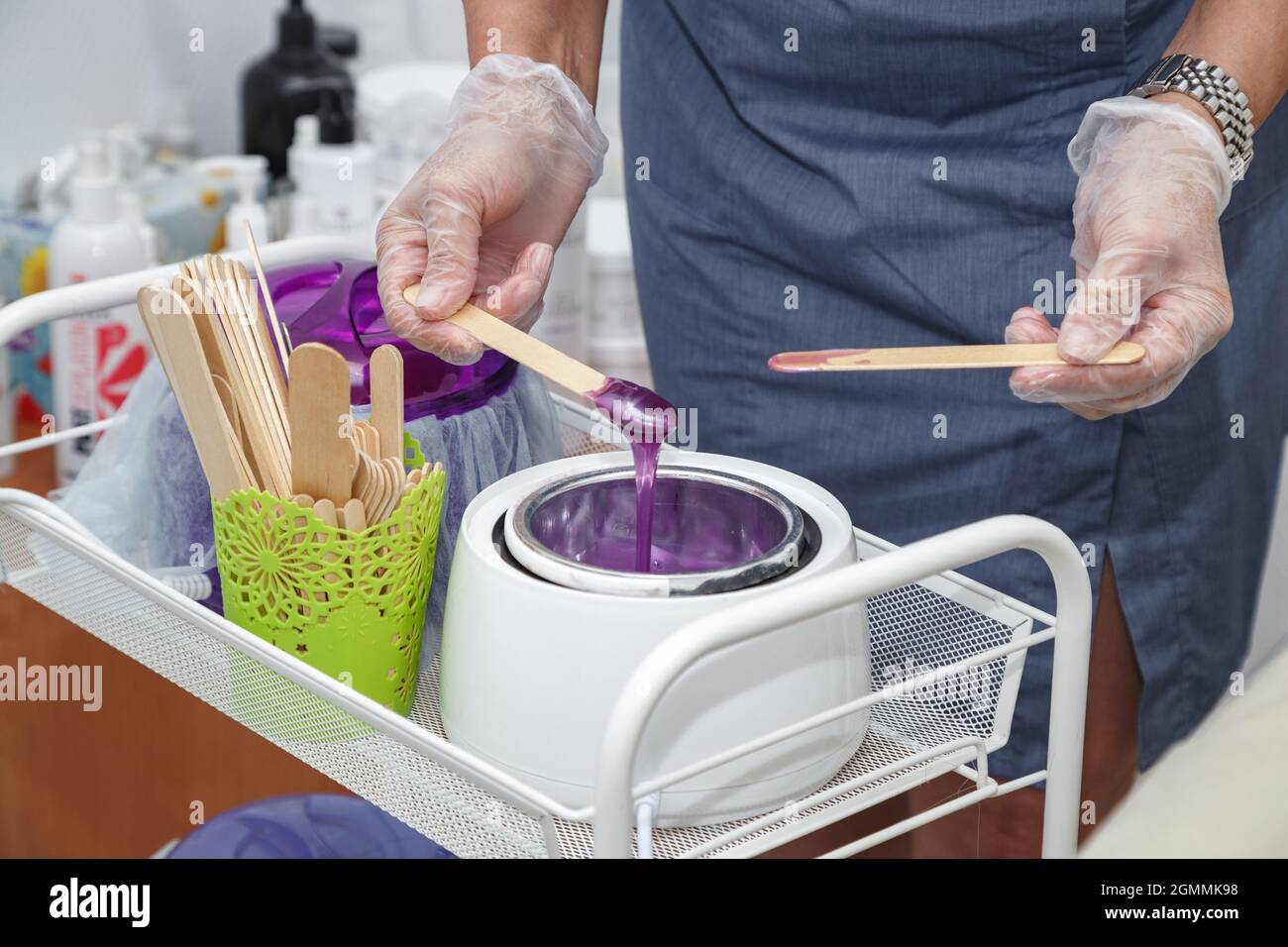 Melted purple wax on wooden stick for depilation Stock Photo - Alamy