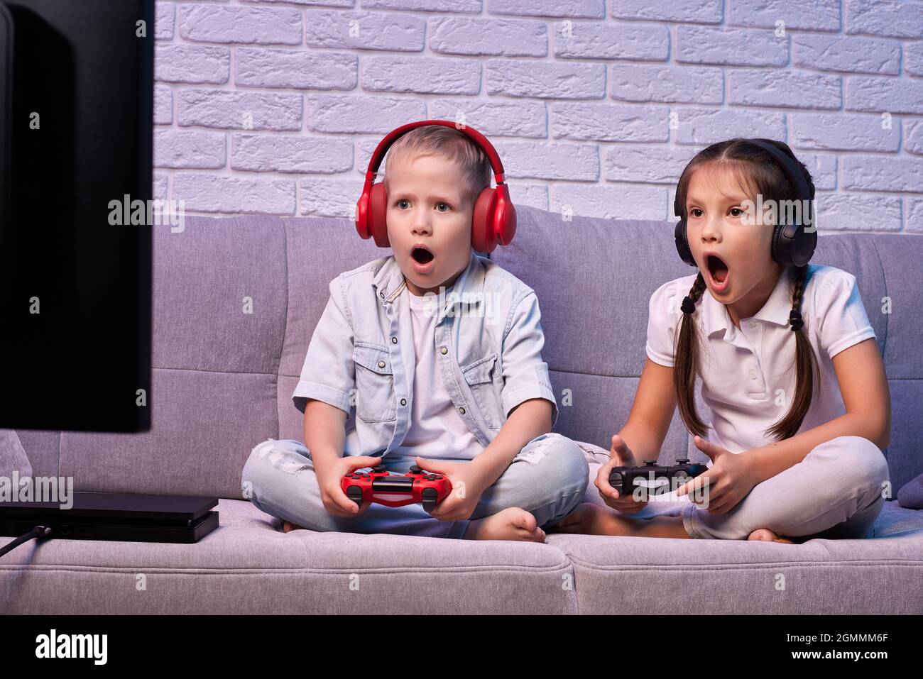 children playing video game with game console Stock Photo - Alamy