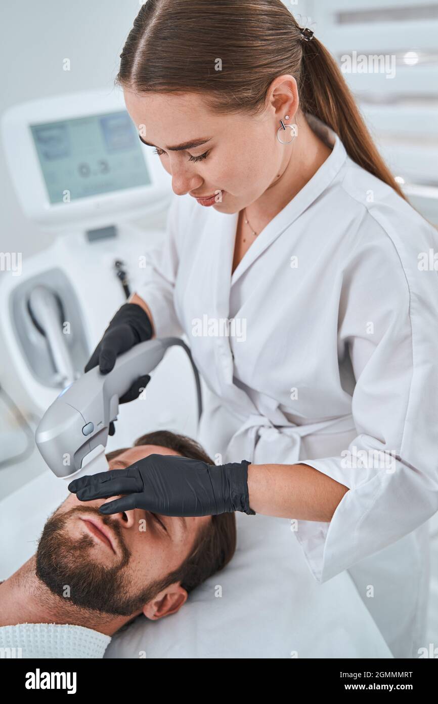 Man undergoing a non-invasive skin tightening procedure in a beauty ...