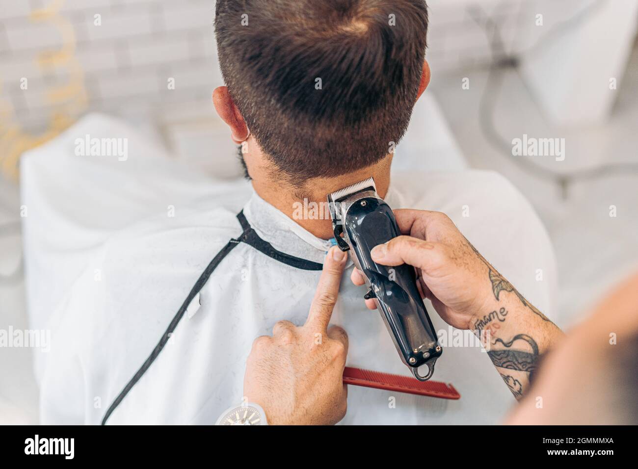 Aerial view of a barber cutting the hair of a man using an electric ...