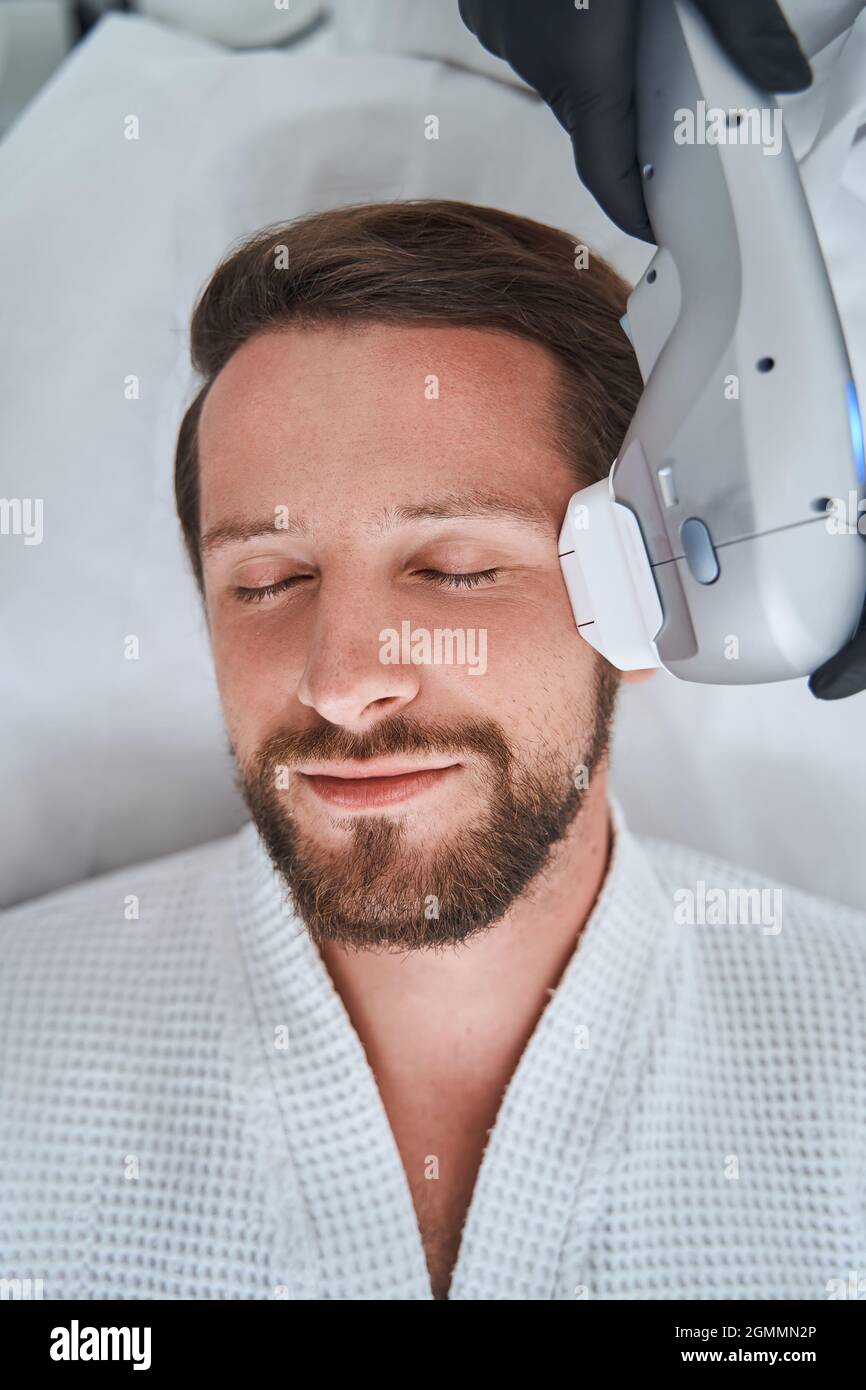 Male spa client relaxing during a skin tightening procedure Stock Photo ...