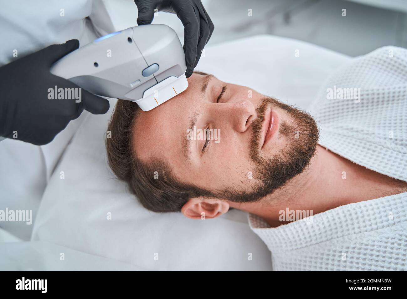 Dark-haired Caucasian spa client undergoing a skin rejuvenation ...