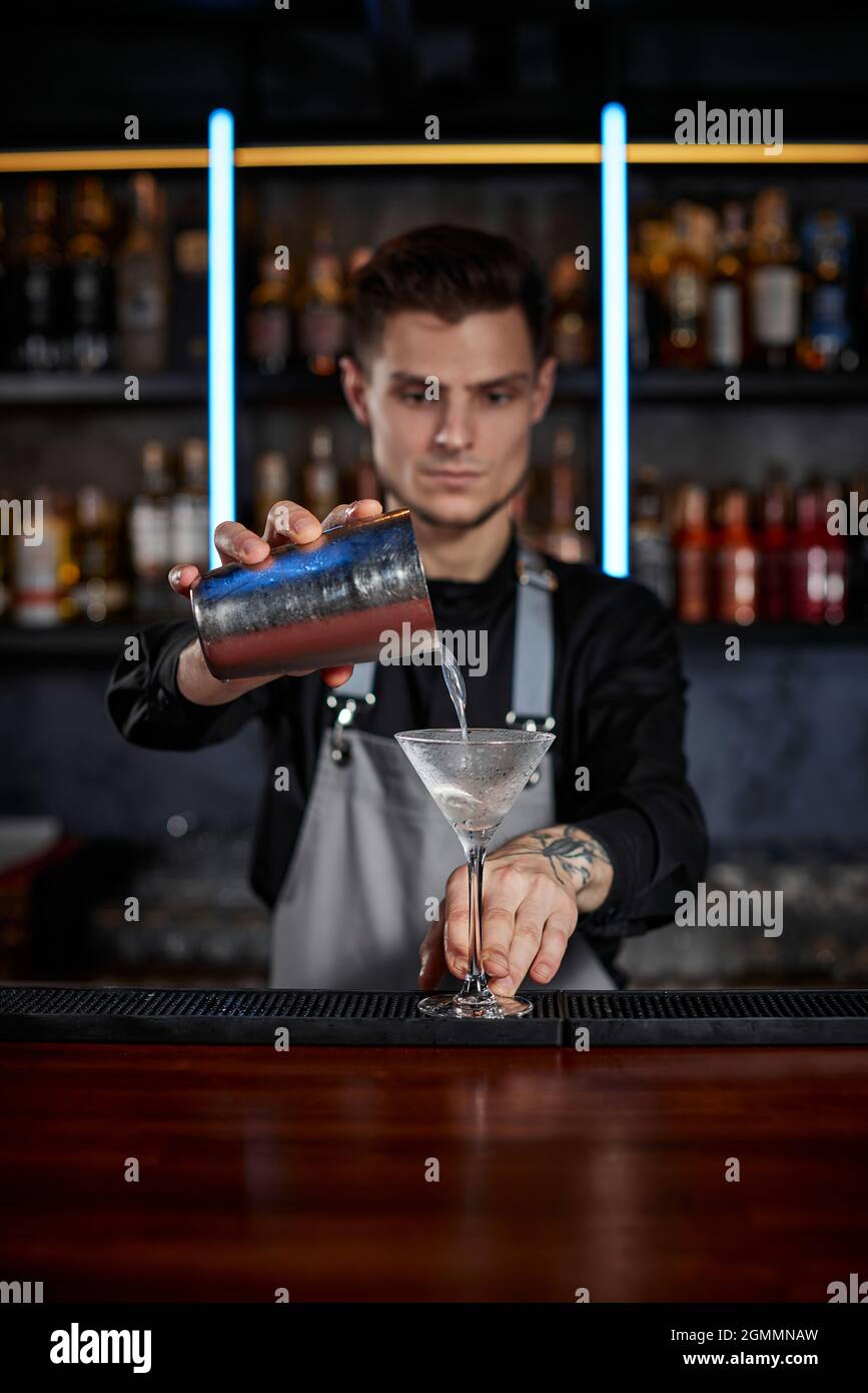 barman is making cocktail with steel shaker Stock Photo - Alamy