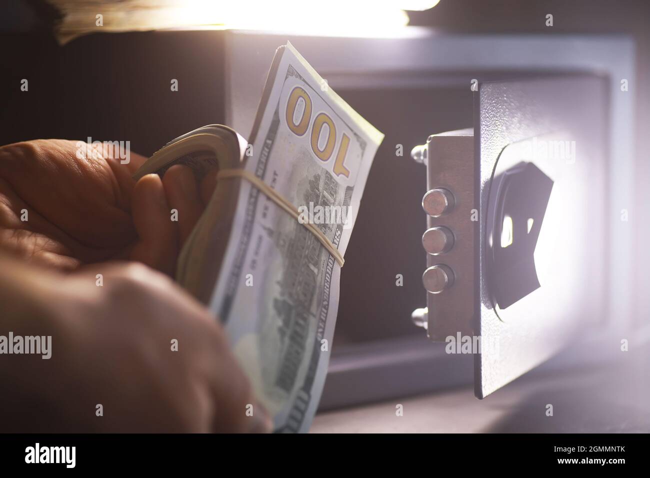 Steel safe with money. Hand putting password in the safety money box in ...