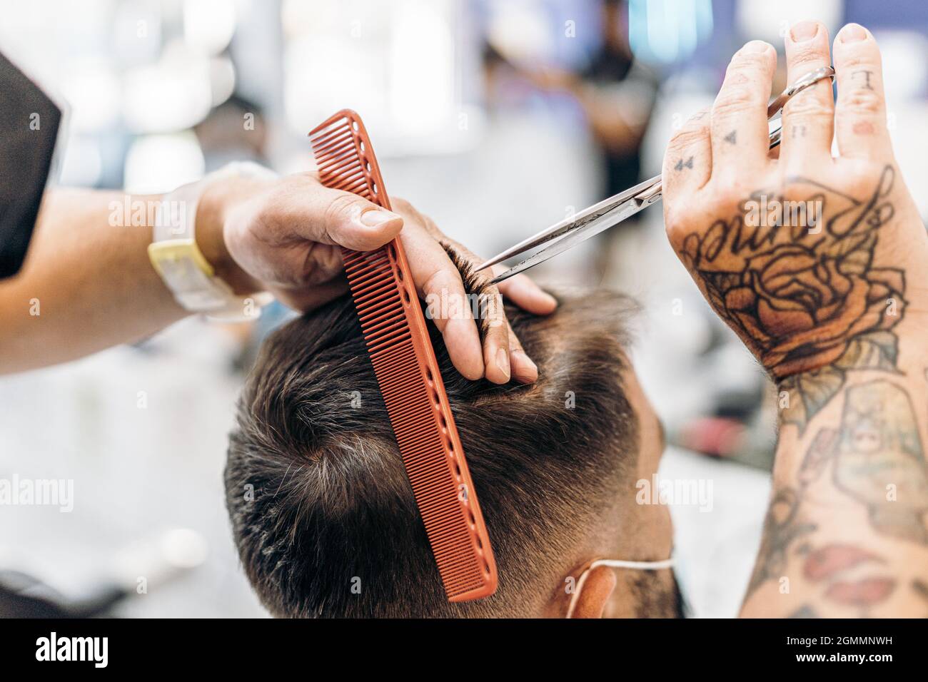 Tattooed hands of a barber cutting the hair of a client Stock Photo - Alamy