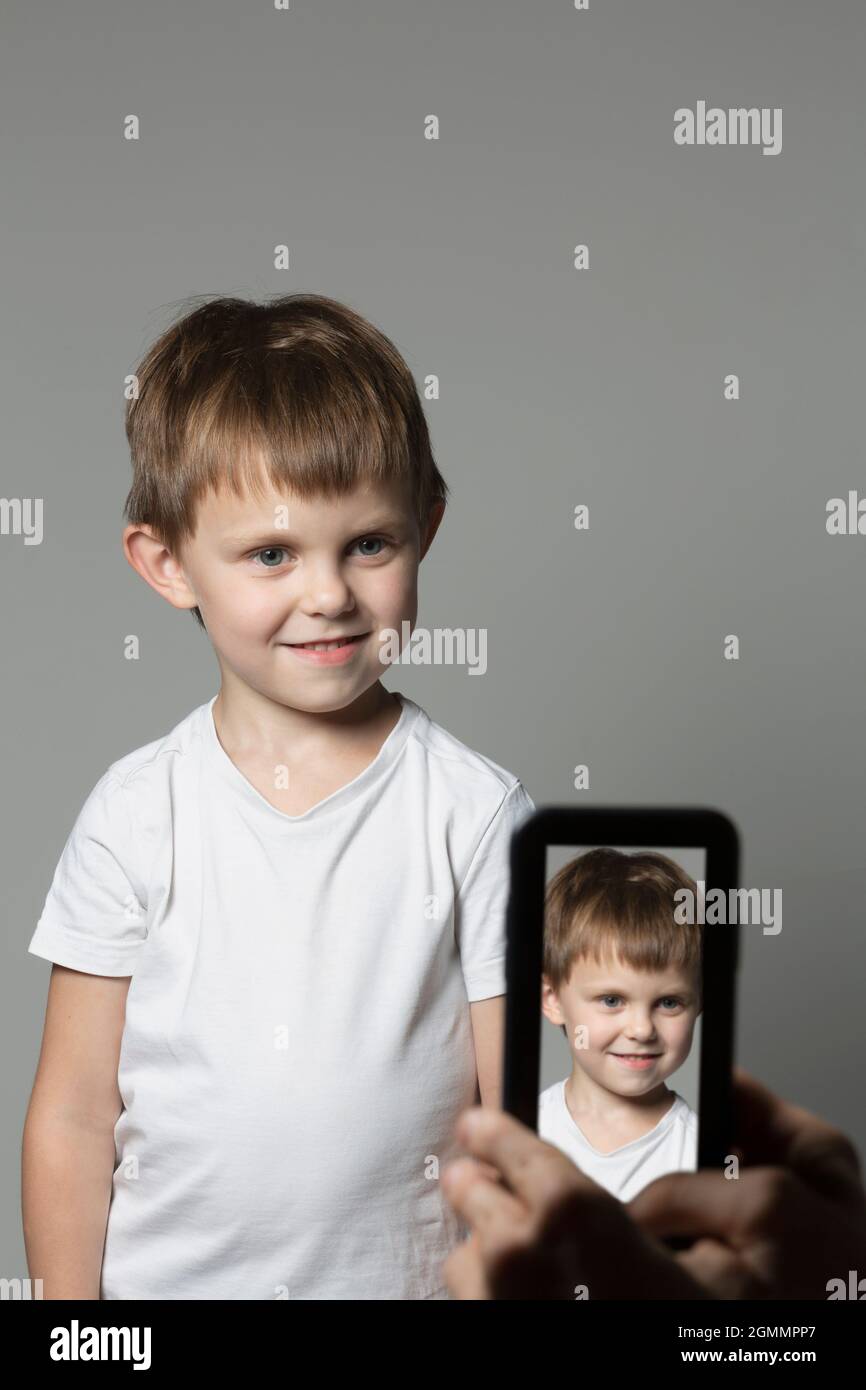 Cute boy posing for smart phone photo Stock Photo - Alamy