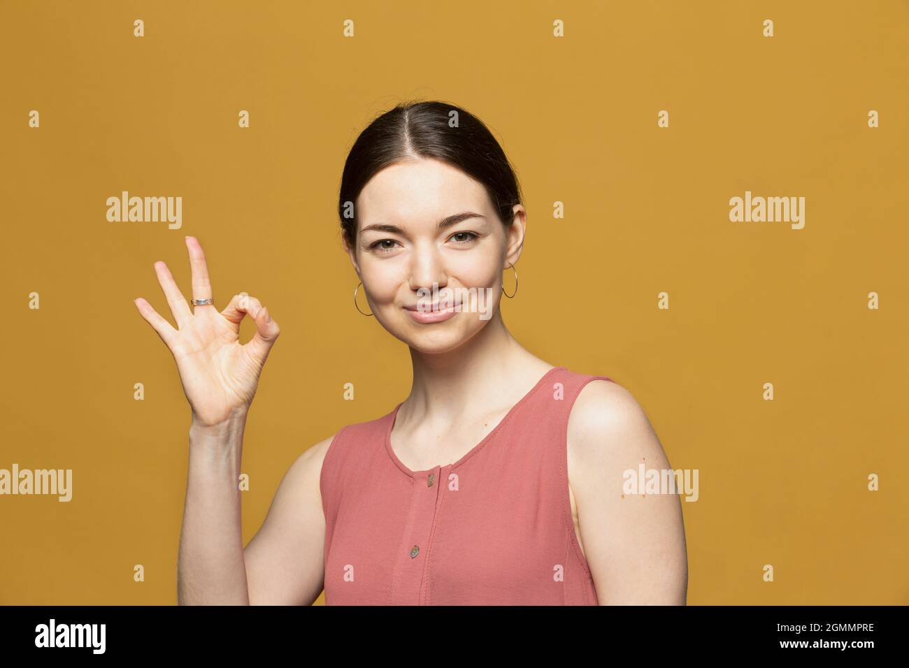 Portrait happy young woman gesturing OK Stock Photo - Alamy