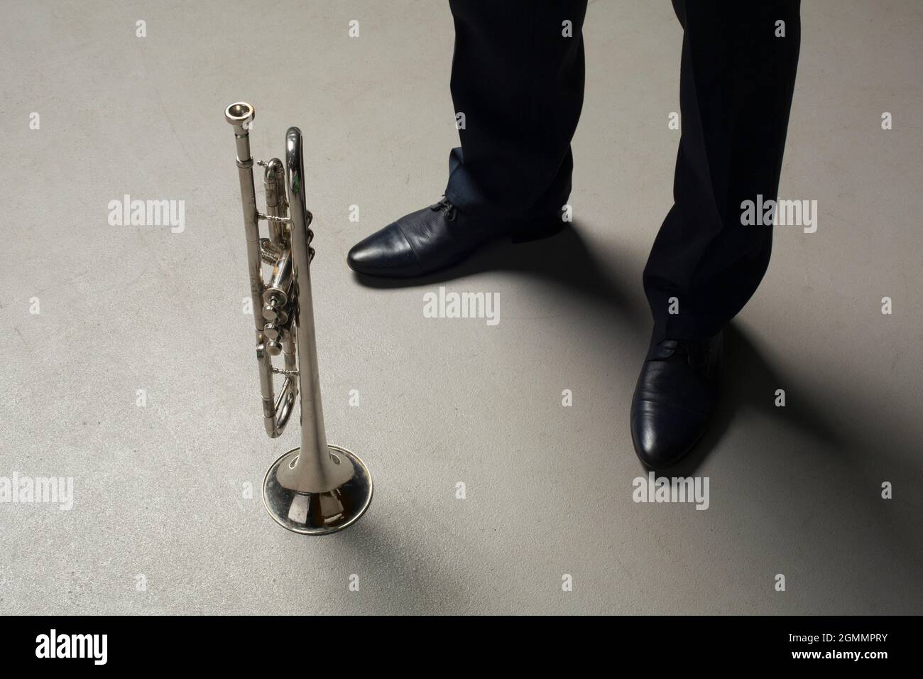 Man standing next to trumpet Stock Photo - Alamy