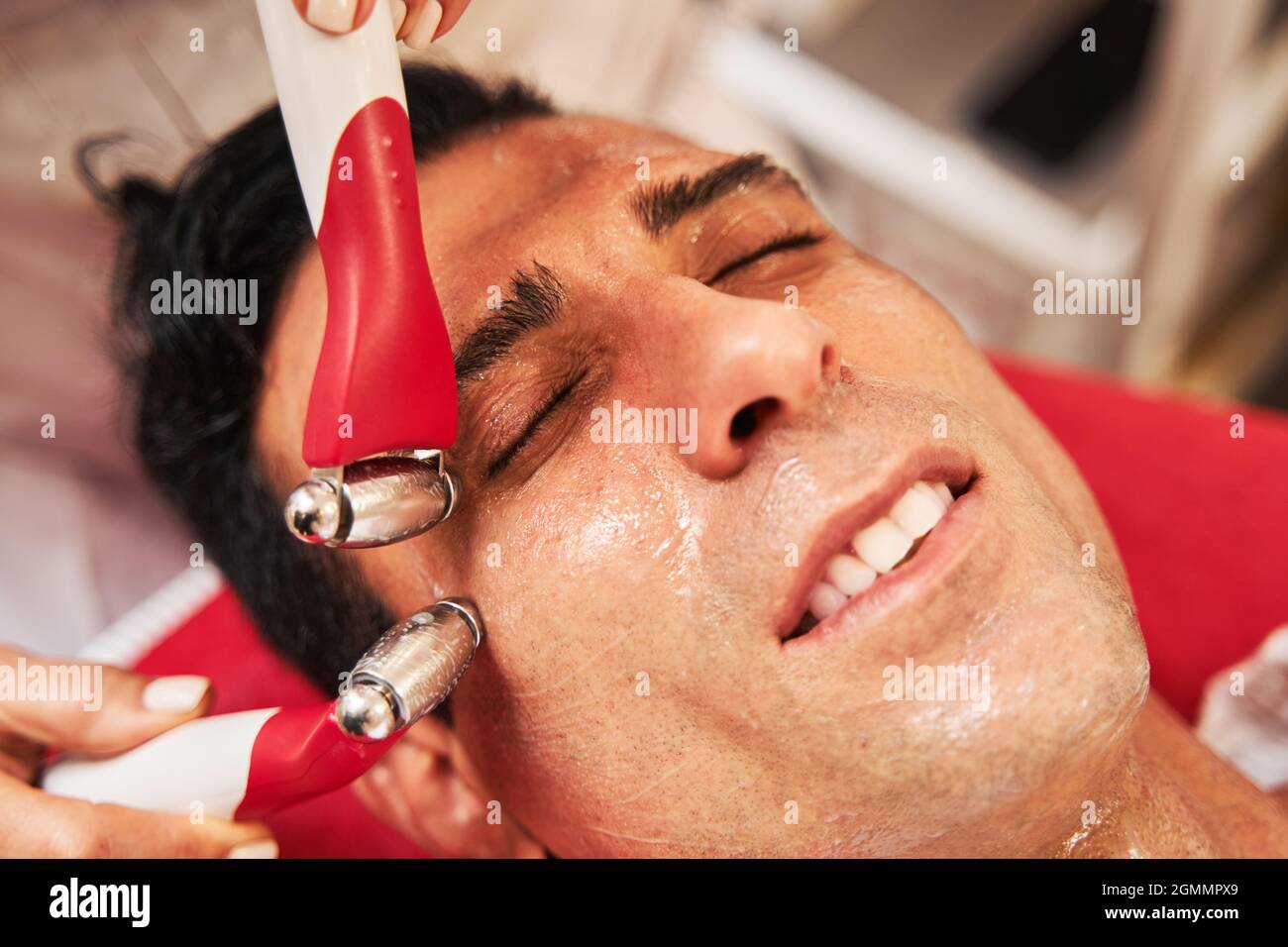 Tools for electric stimulation touching man face Stock Photo - Alamy