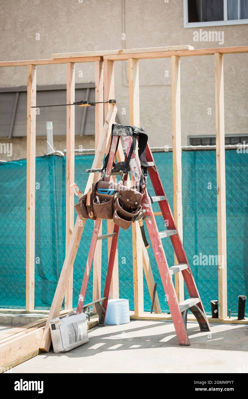 Tool belt hanging on ladder at construction site Stock Photo - Alamy