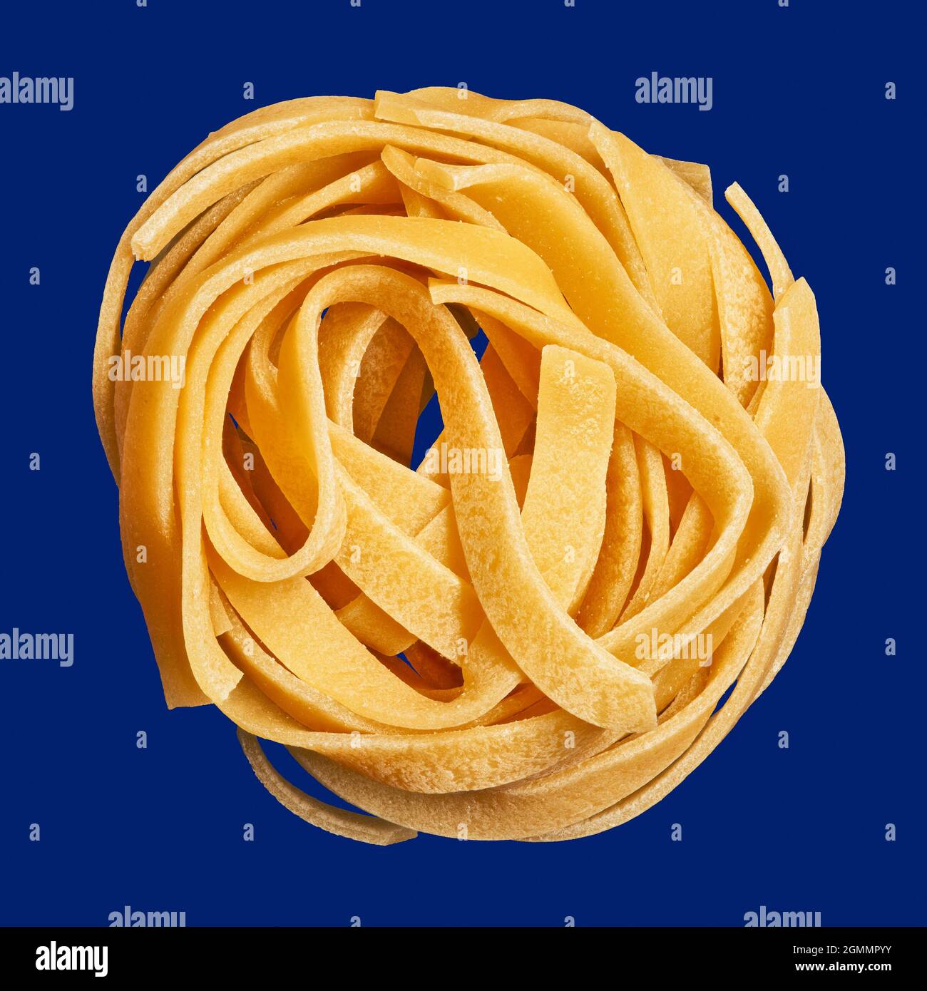 Close up uncooked spaghetti pasta nest on blue background Stock Photo ...