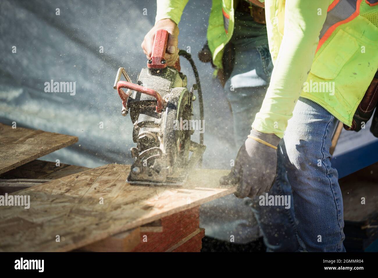 Construction worker using saw on plywood Stock Photo - Alamy