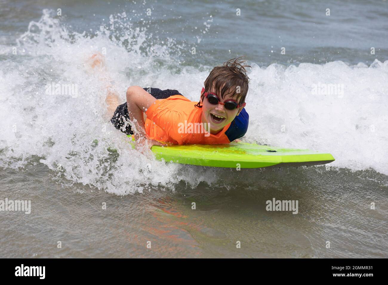 Portrait happy boy bodyboarding in ocean Stock Photo - Alamy