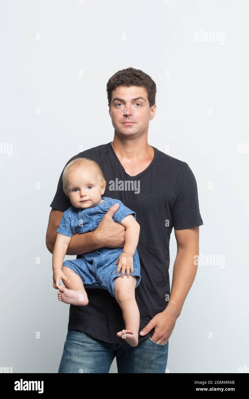 Portrait confident father holding baby son on white background Stock ...