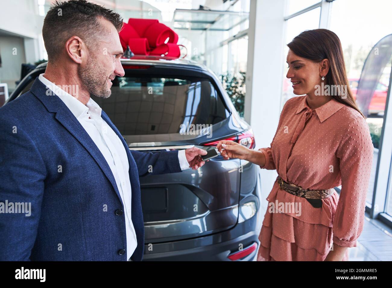 Friendly people in car dealership sharing the keys and smiling Stock ...