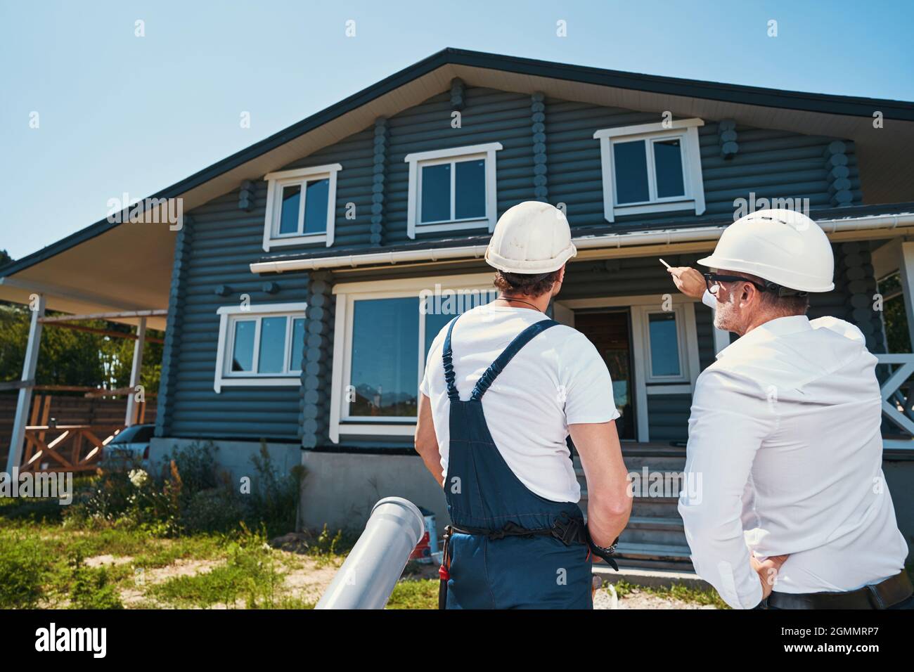 Two engineers staring at private house from yard Stock Photo - Alamy