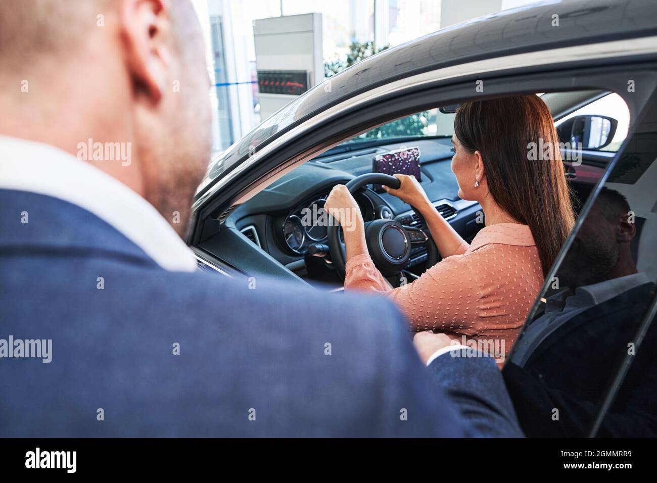 Female driver in the car showroom ready to go Stock Photo - Alamy