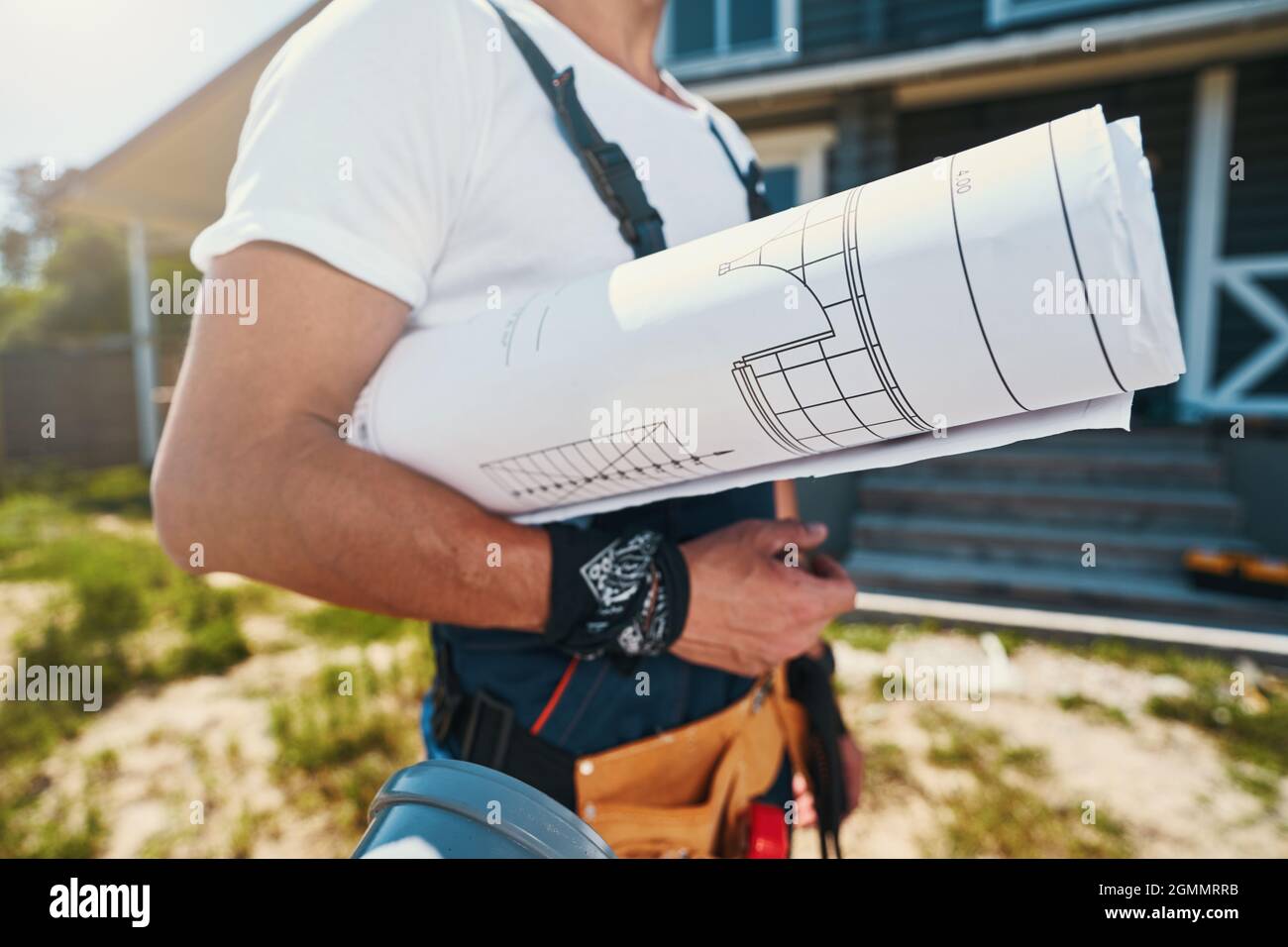 Housebuilder carrying blueprints and tools with him Stock Photo - Alamy