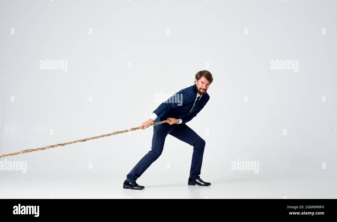 business man in a suit pulls the rope emotions studio Stock Photo - Alamy