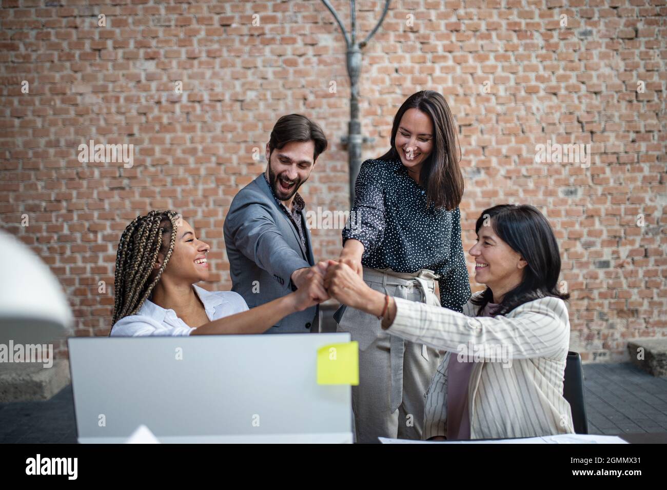 Cheerful young and old businesspeople celebrating success in office ...