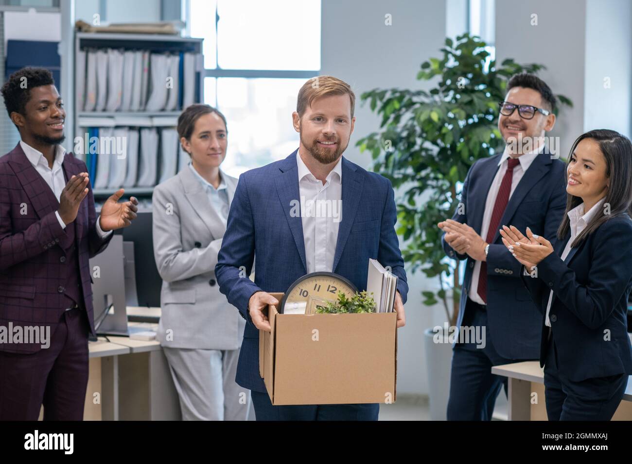 Group of intercultural colleagues clapping hands to new employee ...