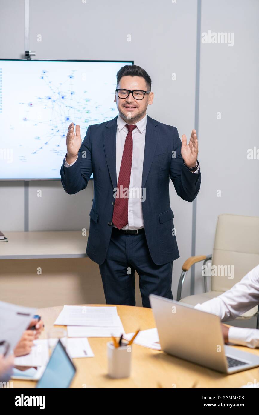 Successful coach in formalwear explaining points of business course to ...