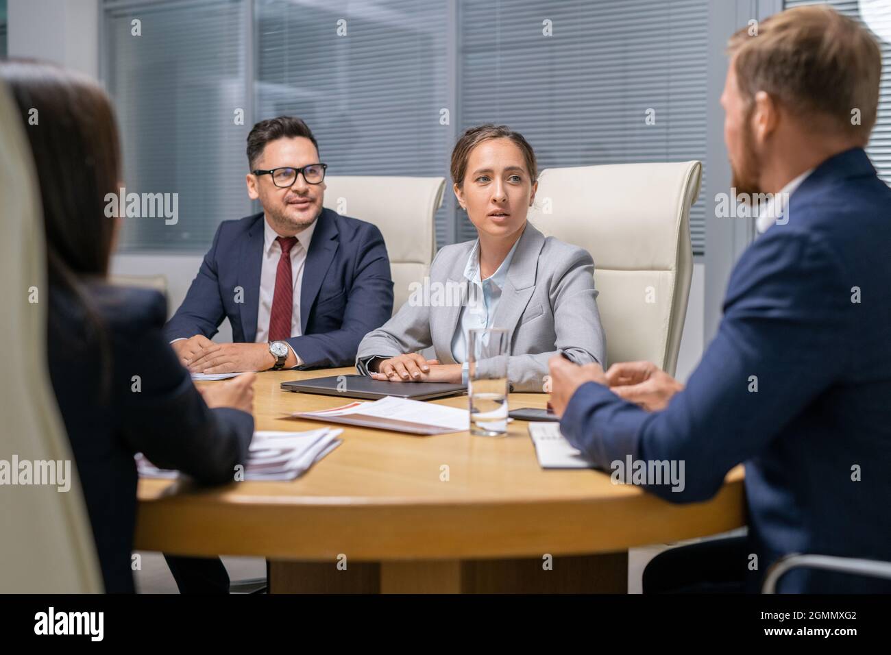 Group of young colleagues discussing working points at meeting in ...