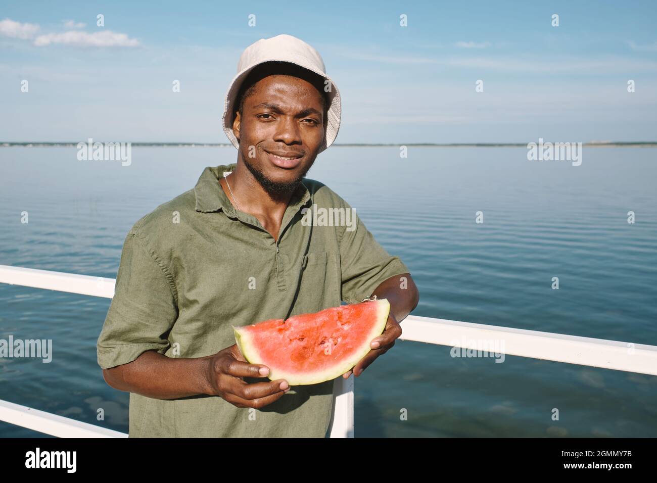 Happy guy of African ethnicity holding slice of juicy watermelon ...