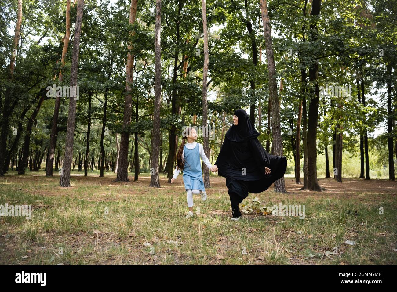Muslim mother and kid running while playing in park Stock Photo - Alamy