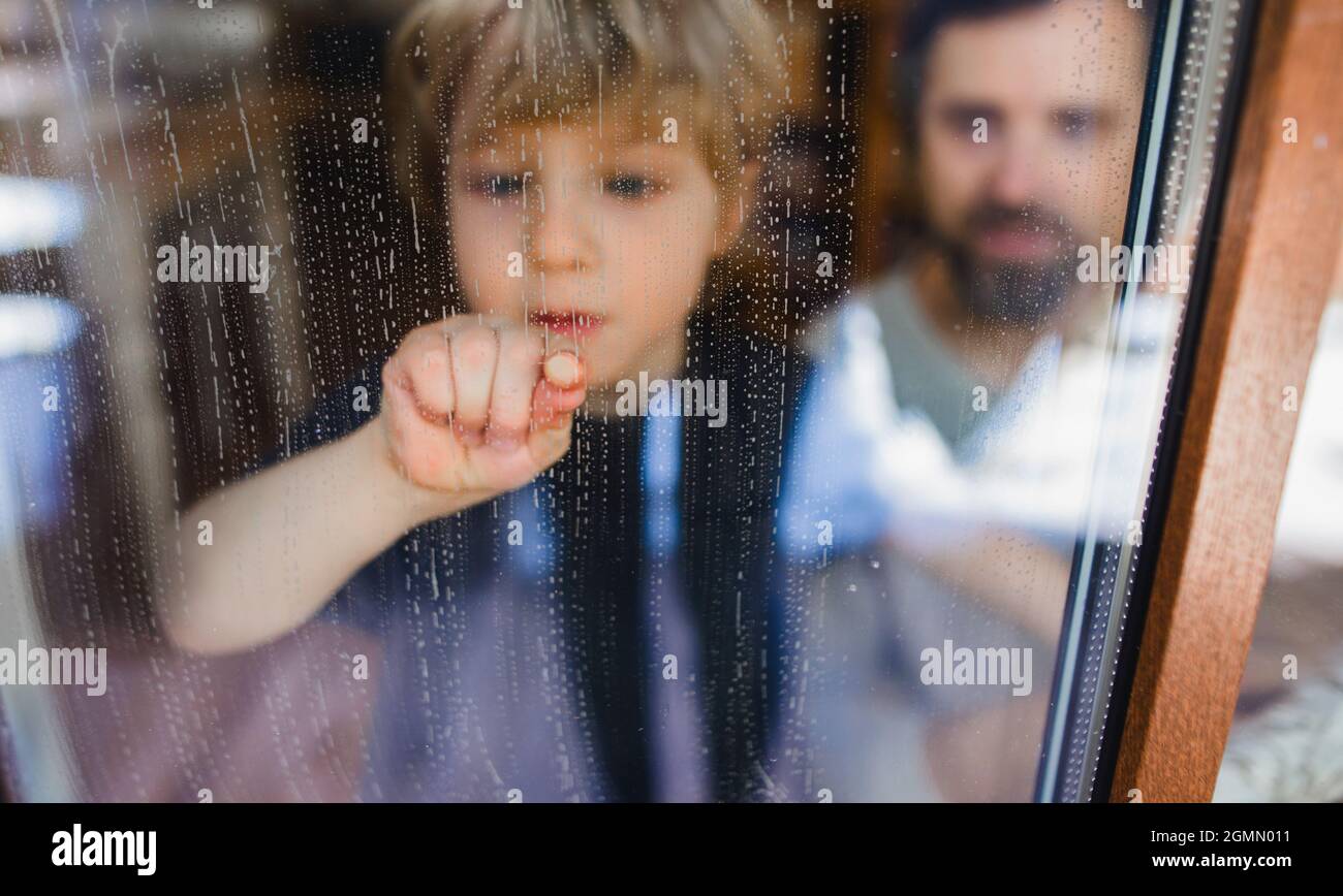 Sad Boy With Unrecognizable Father Looking Through Dirty Window