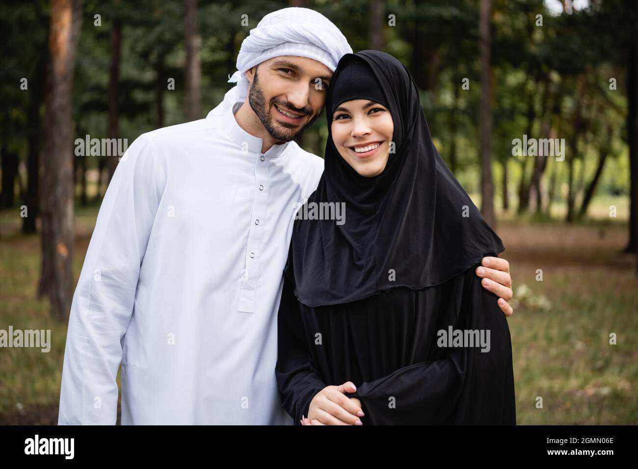 Muslim couple in traditional clothes smiling at camera outdoors Stock ...