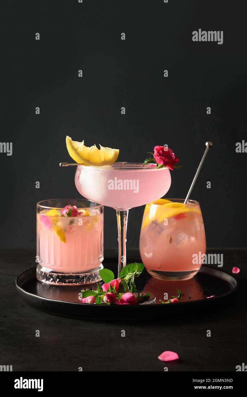 Freshness pink alcoholic cocktails with rose, gin and lemon on black ...