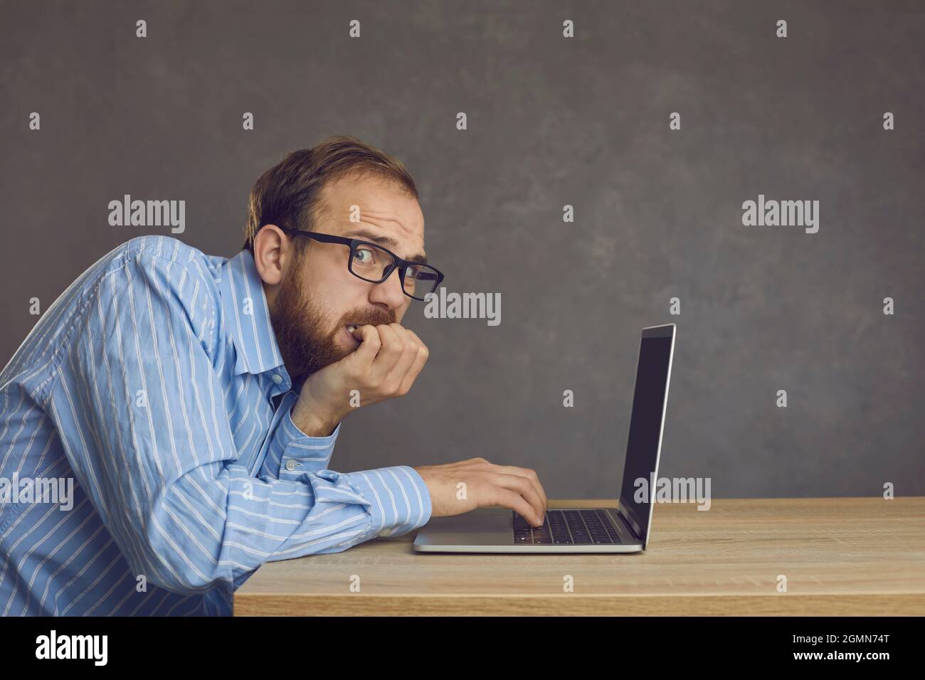 Scared stressed man who has made a mistake biting nails sitting at ...