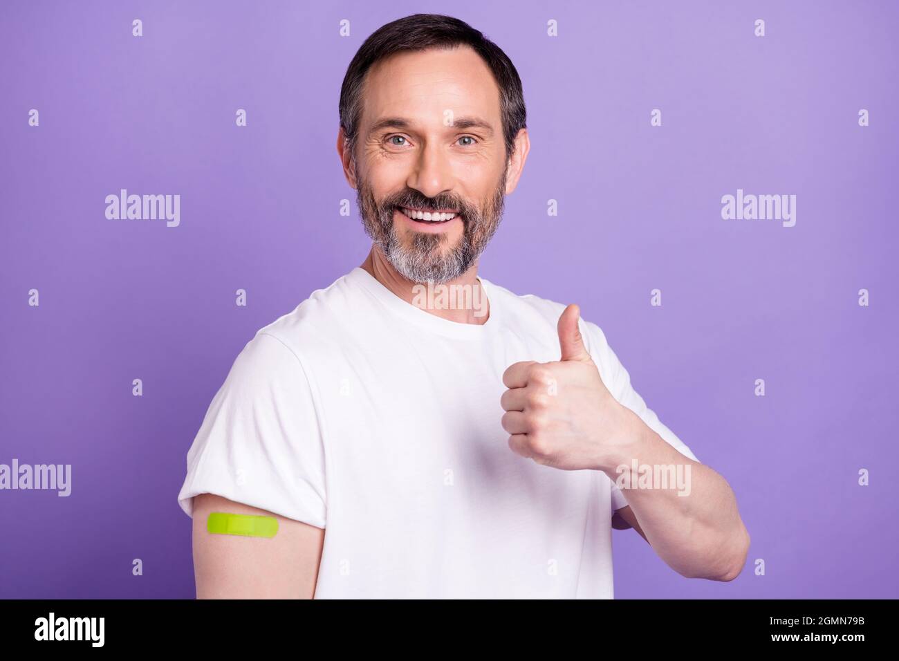 Photo of charming pretty mature man dressed white t-shirt showing thumb ...