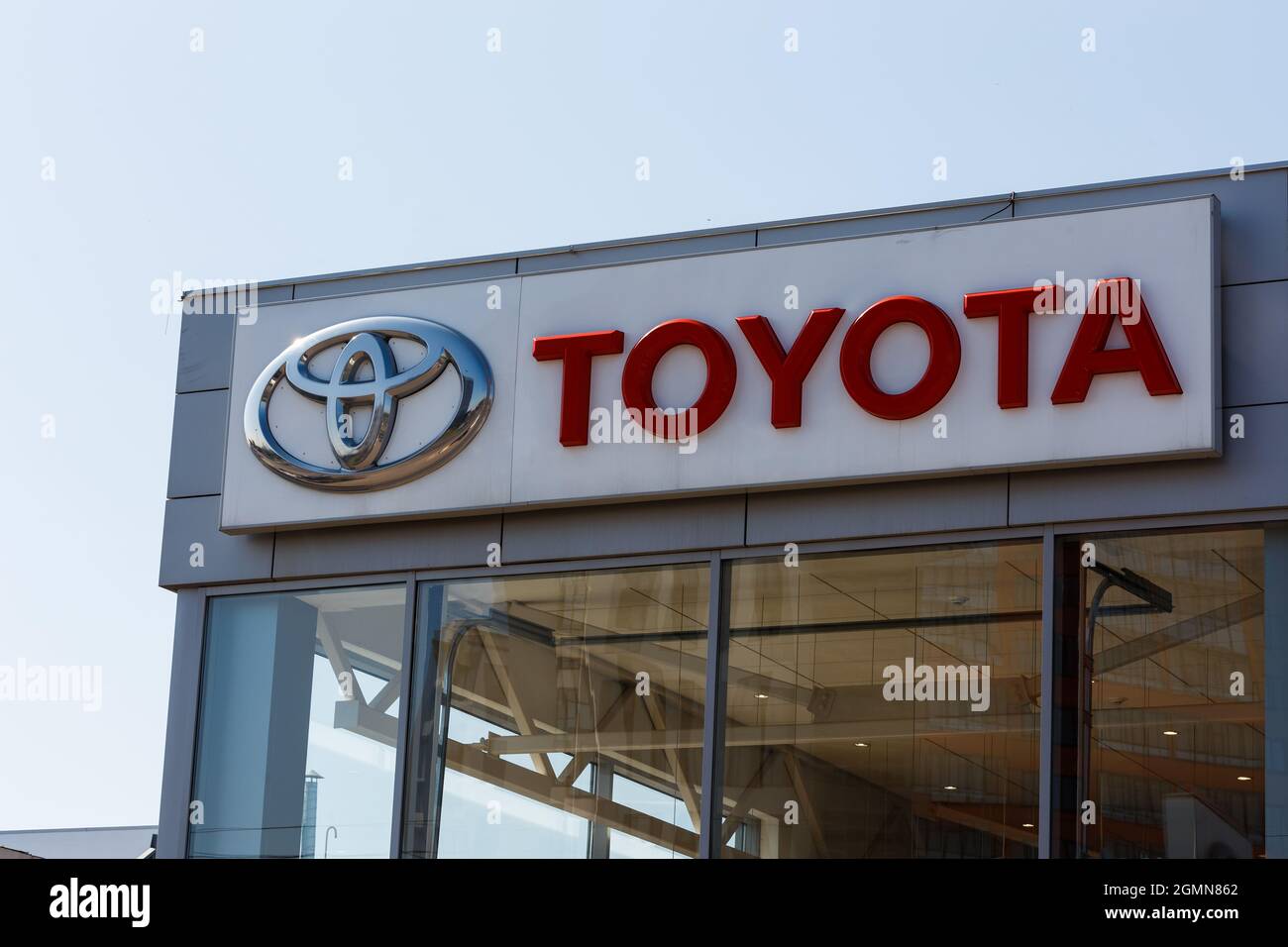 Toyota logo on car dealership building at sunny day - Toyota Motor ...