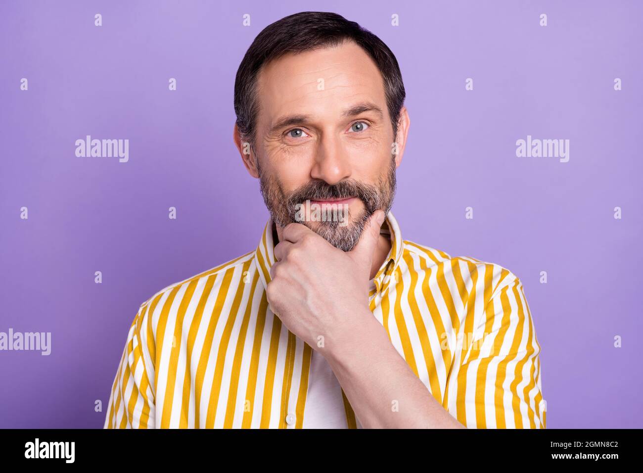 Photo of mature minded attractive man hold hand chin good mood smile ...