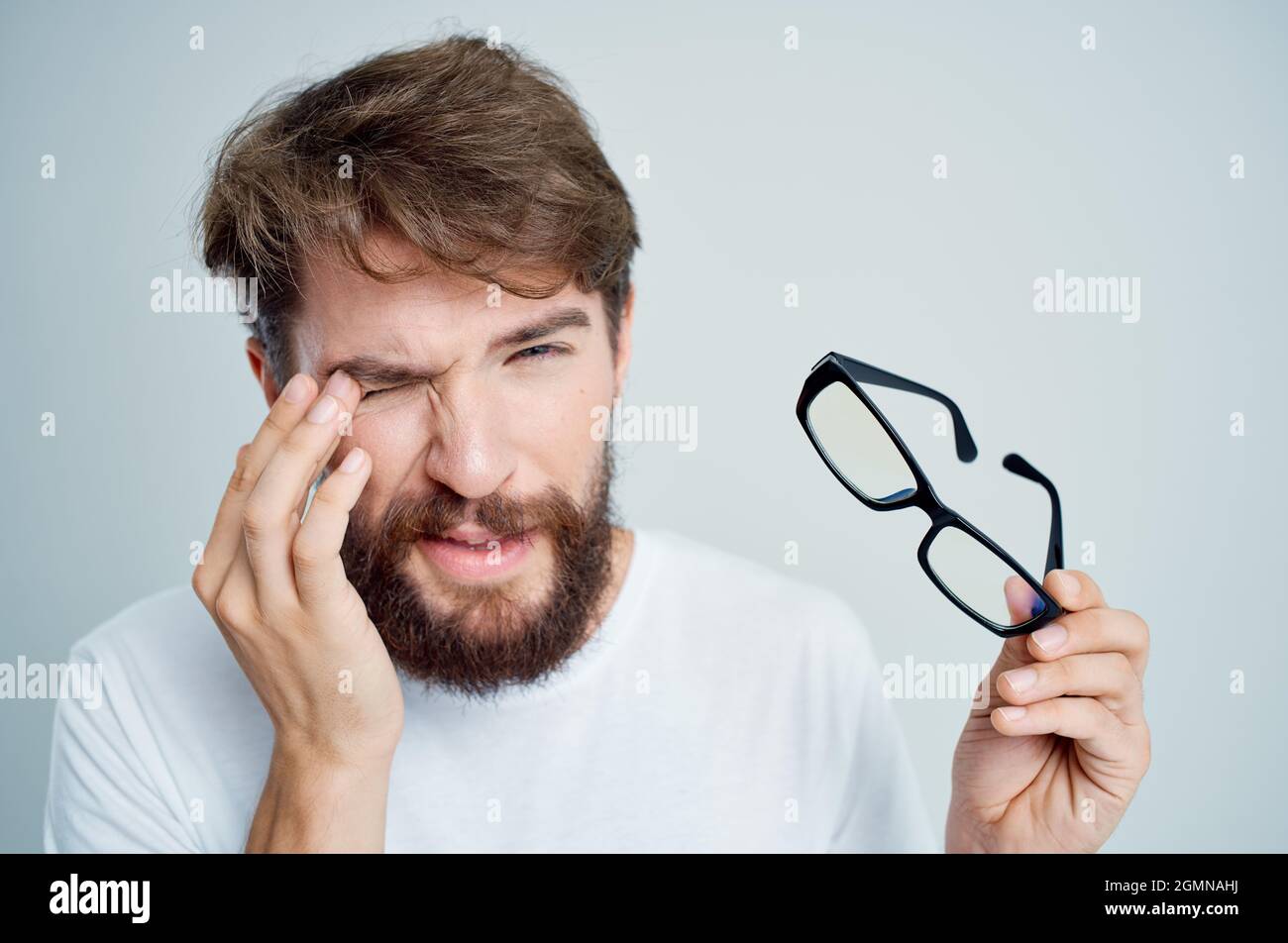 sick man with glasses in hand vision problems light background Stock ...