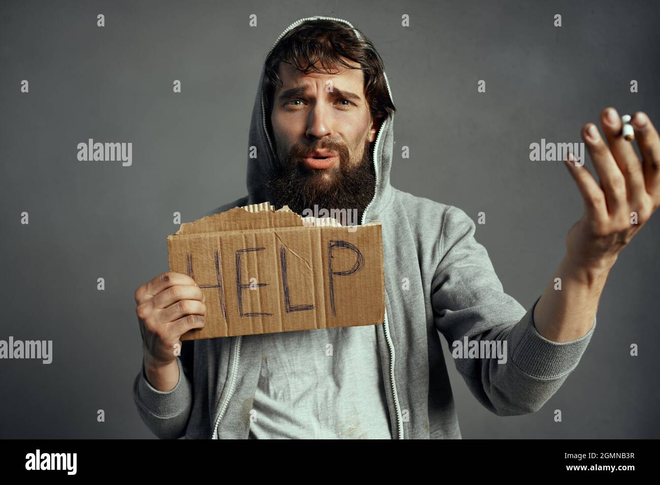 homeless bearded man tramp with cigarette sign help Stock Photo - Alamy